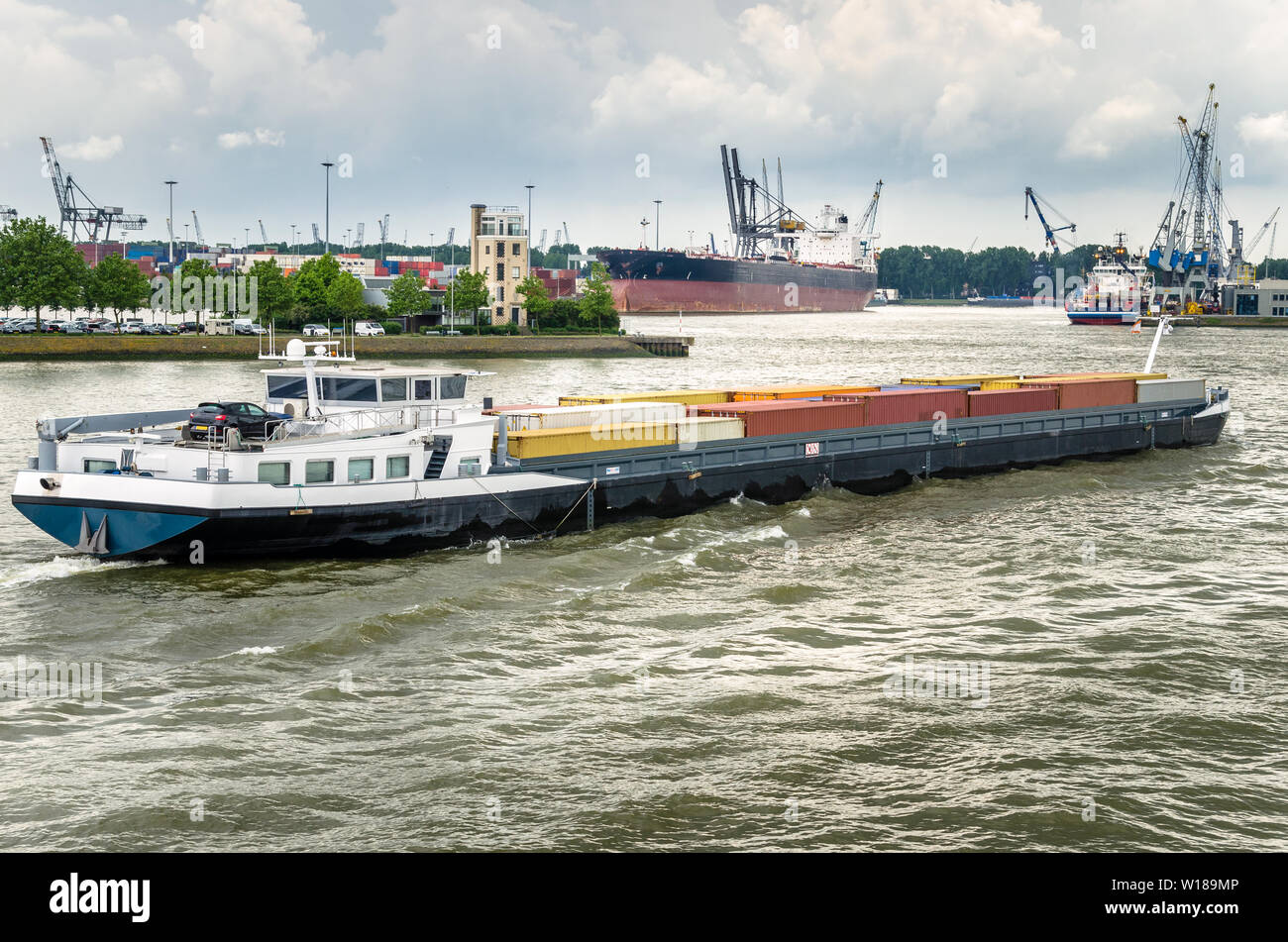 View of a container barge in navigation in a port and cloudy sky Stock ...