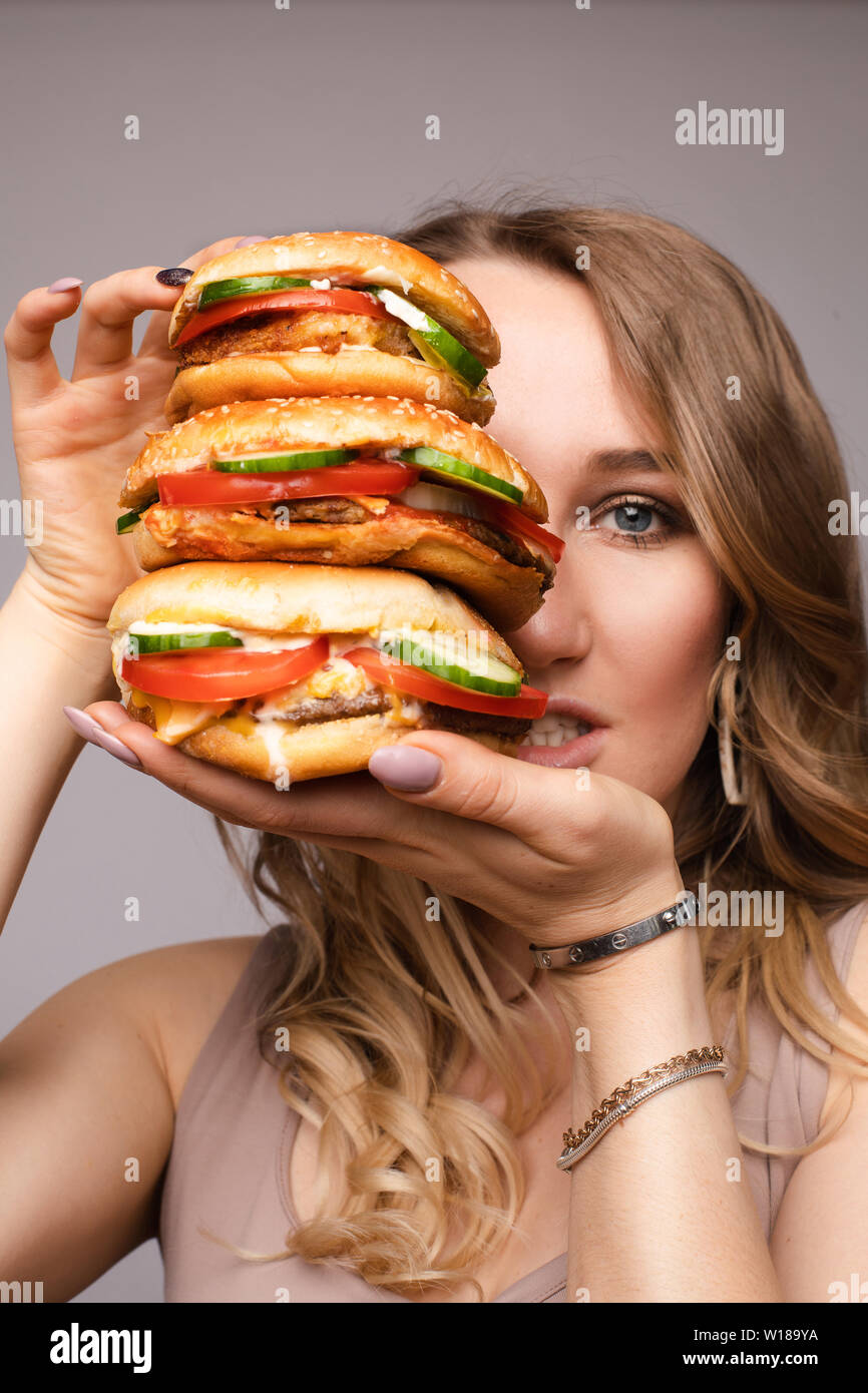 Girl with huge hamburger on hand.Studio portrait of young brunette ...