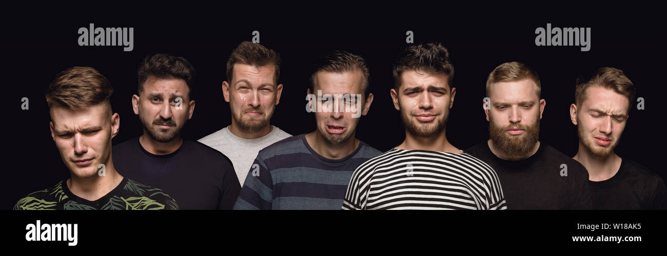 Close up portrait of young men isolated on black studio background ...