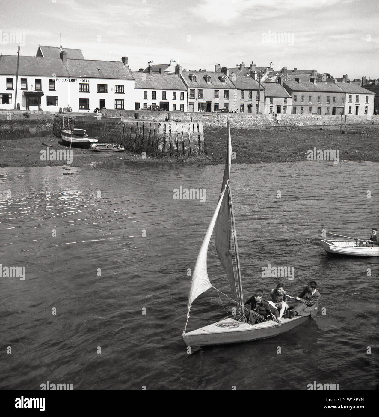 1950s, historical, a father with his two sons on a small sailing boat ...
