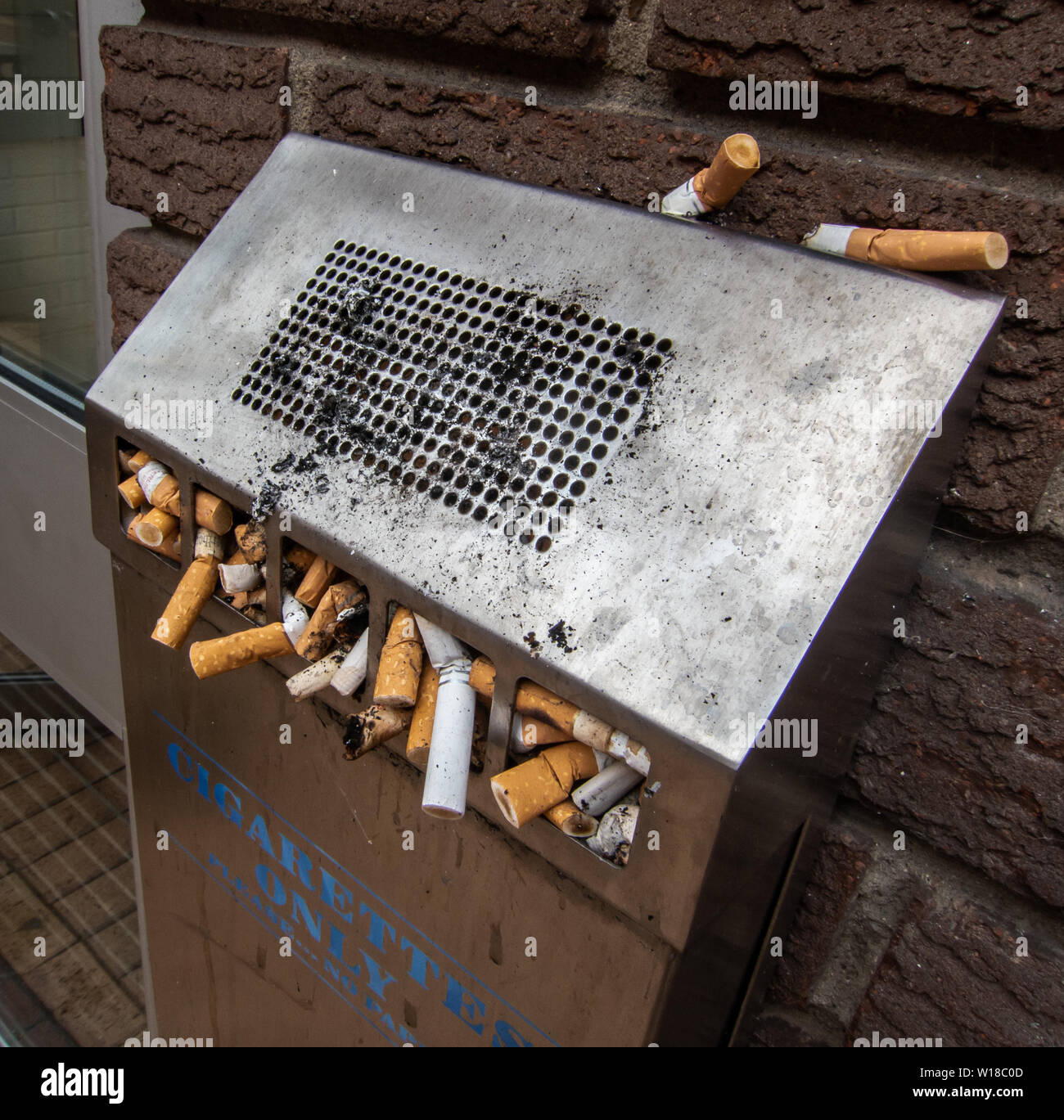 Cigarette stub box full and overflowing Stock Photo - Alamy