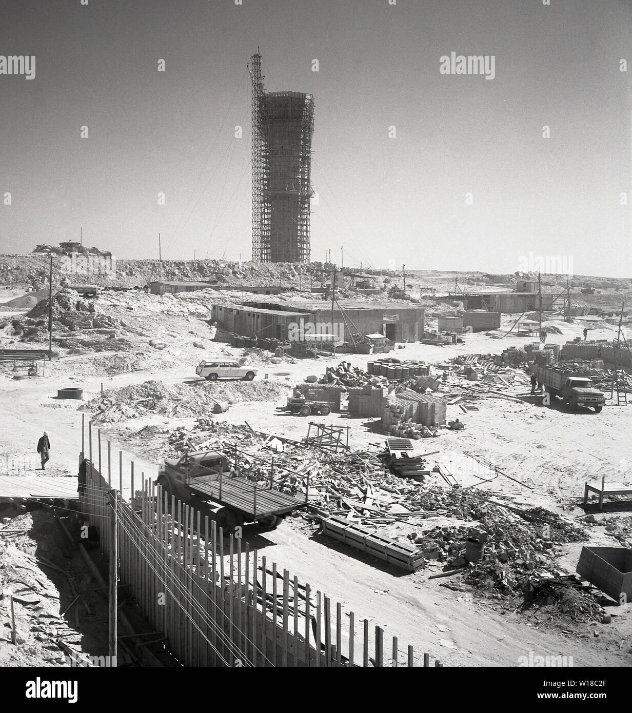 1960s, historical, large construction site in the desert, with tower ...