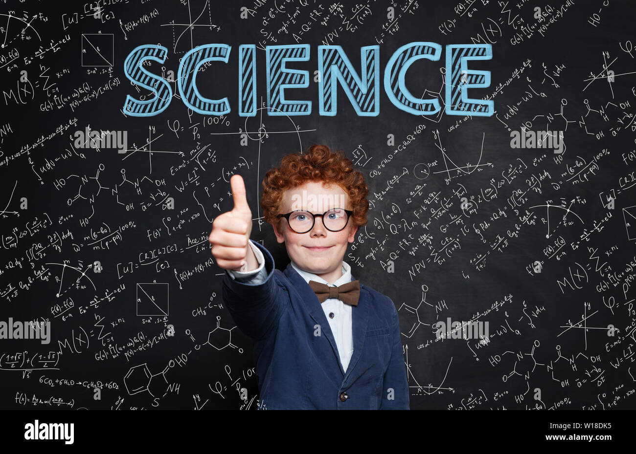 Happy child student holding thumb up on blackboard background with ...