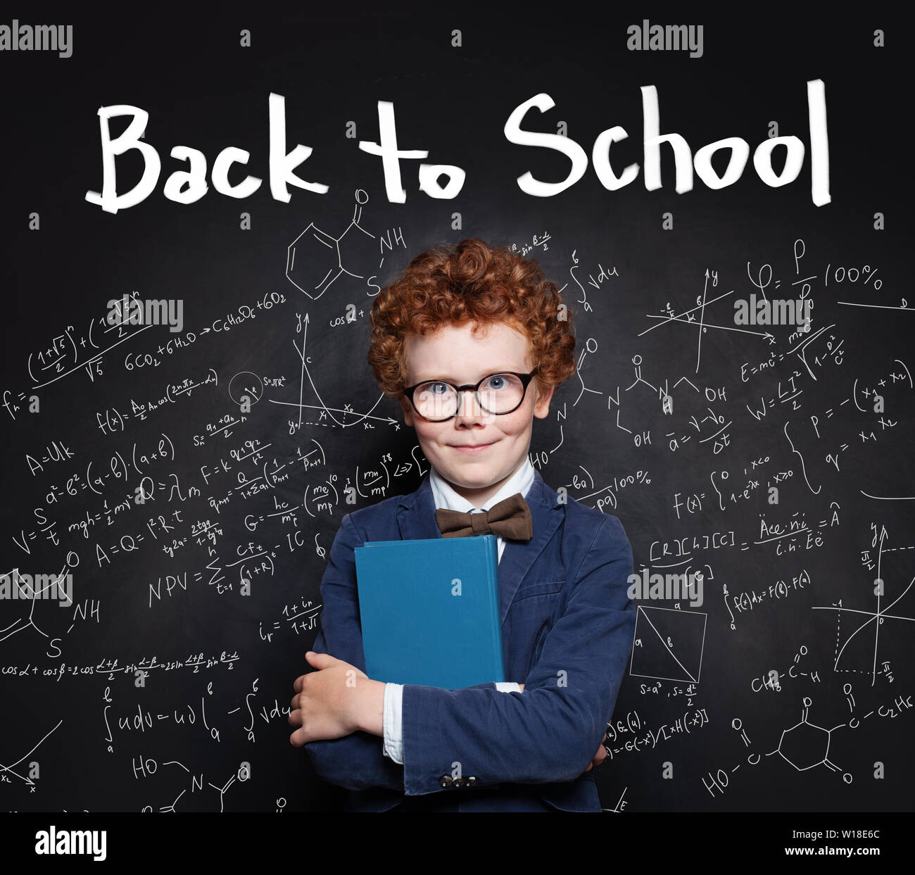 Back to school. Clever child in classroom on chalkboard background with ...