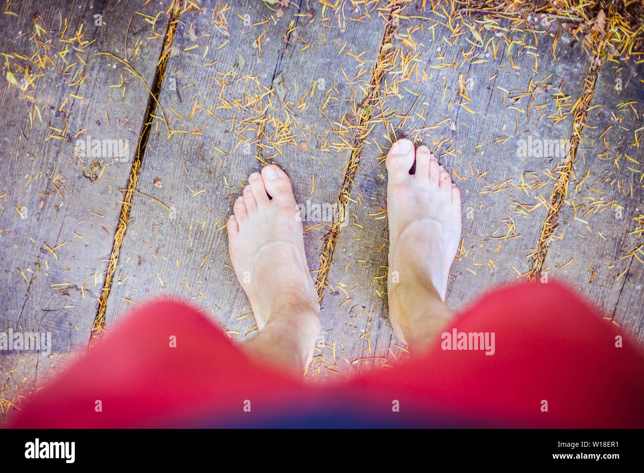 Barefoot feet on a rusty old wooden bridge in the forest, adventure ...