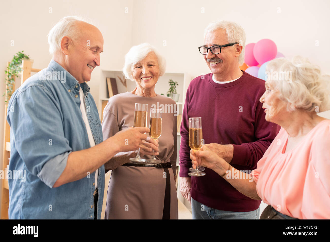 Booze party of four senior friends where they toasting with champagne ...