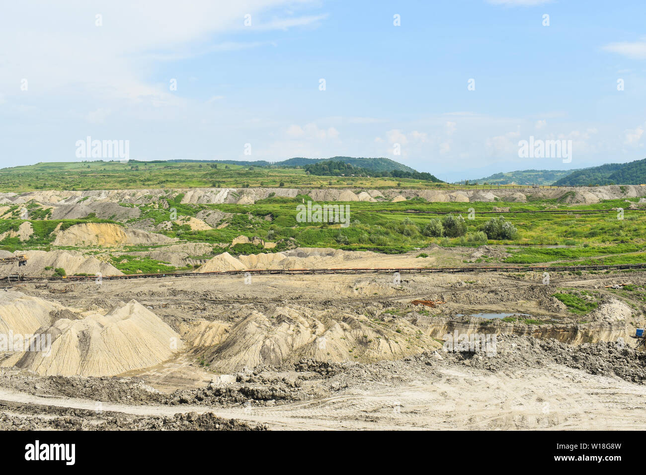 Huge open pit coal mine made with big excavators, loaders, trucks and ...