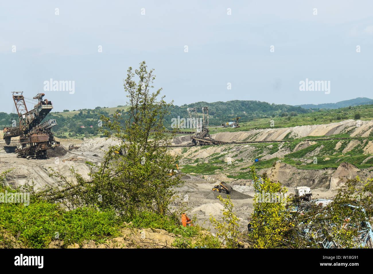 Huge open pit coal mine made with big excavators, loaders, trucks and ...