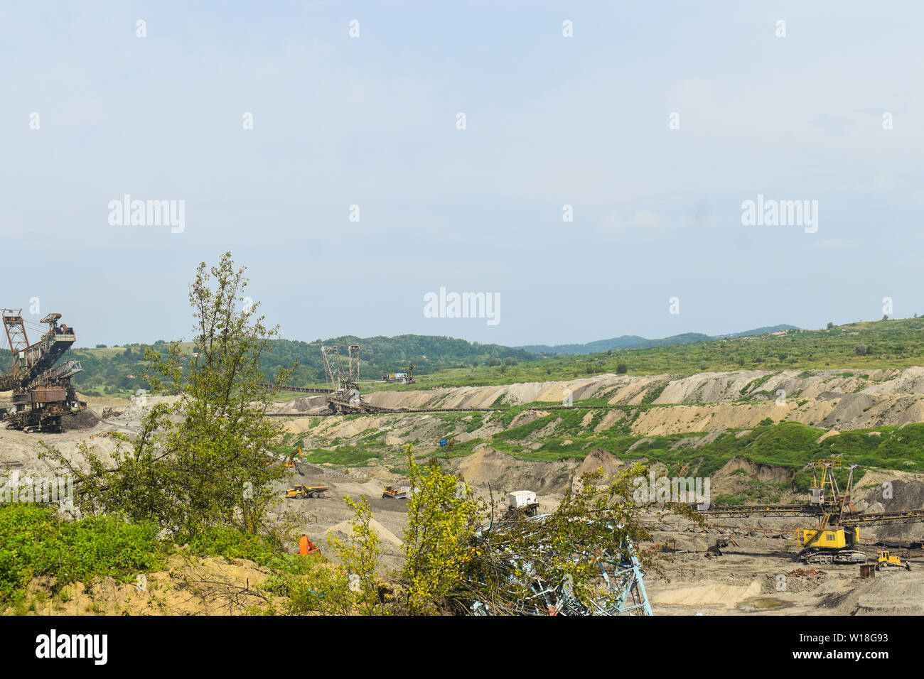 Huge open pit coal mine made with big excavators, loaders, trucks and ...