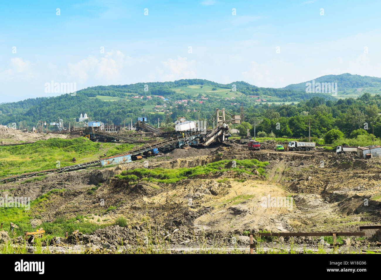 Huge open pit coal mine made with big excavators, loaders, trucks and ...