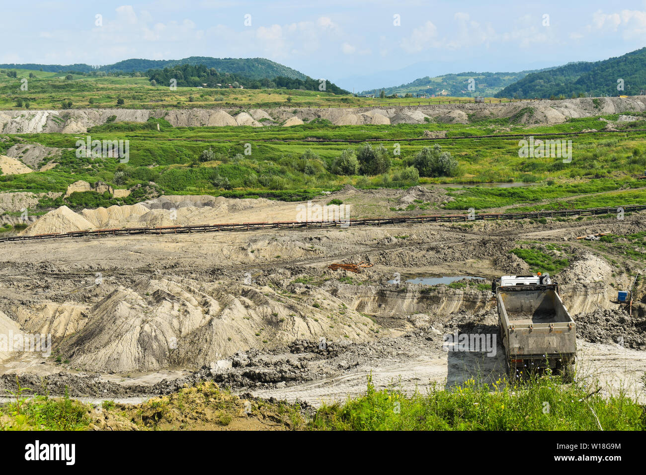Huge open pit coal mine made with big excavators, loaders, trucks and ...