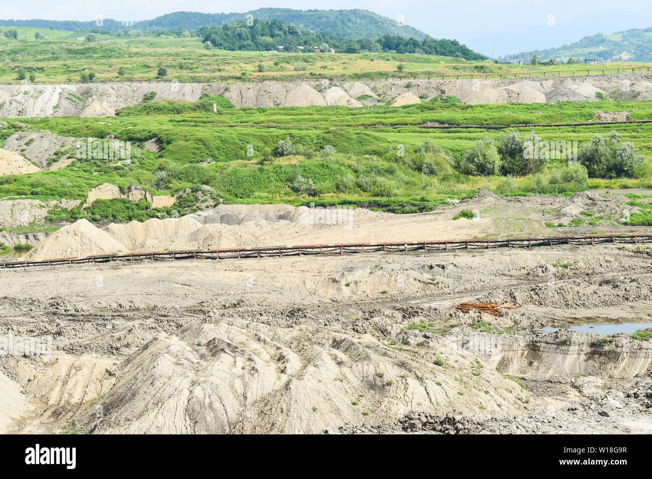 Huge open pit coal mine made with big excavators, loaders, trucks and ...