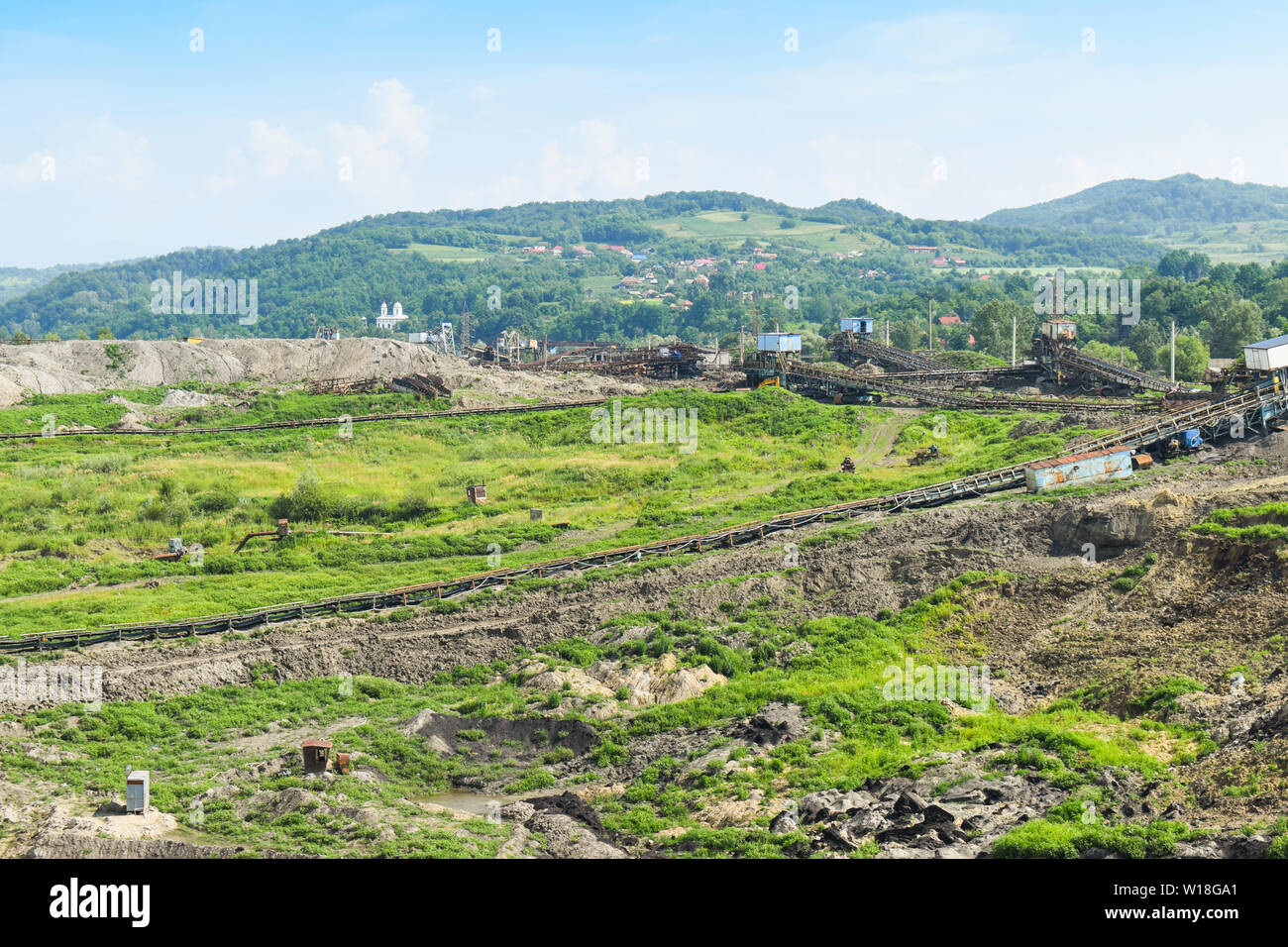 Huge open pit coal mine made with big excavators, loaders, trucks and ...