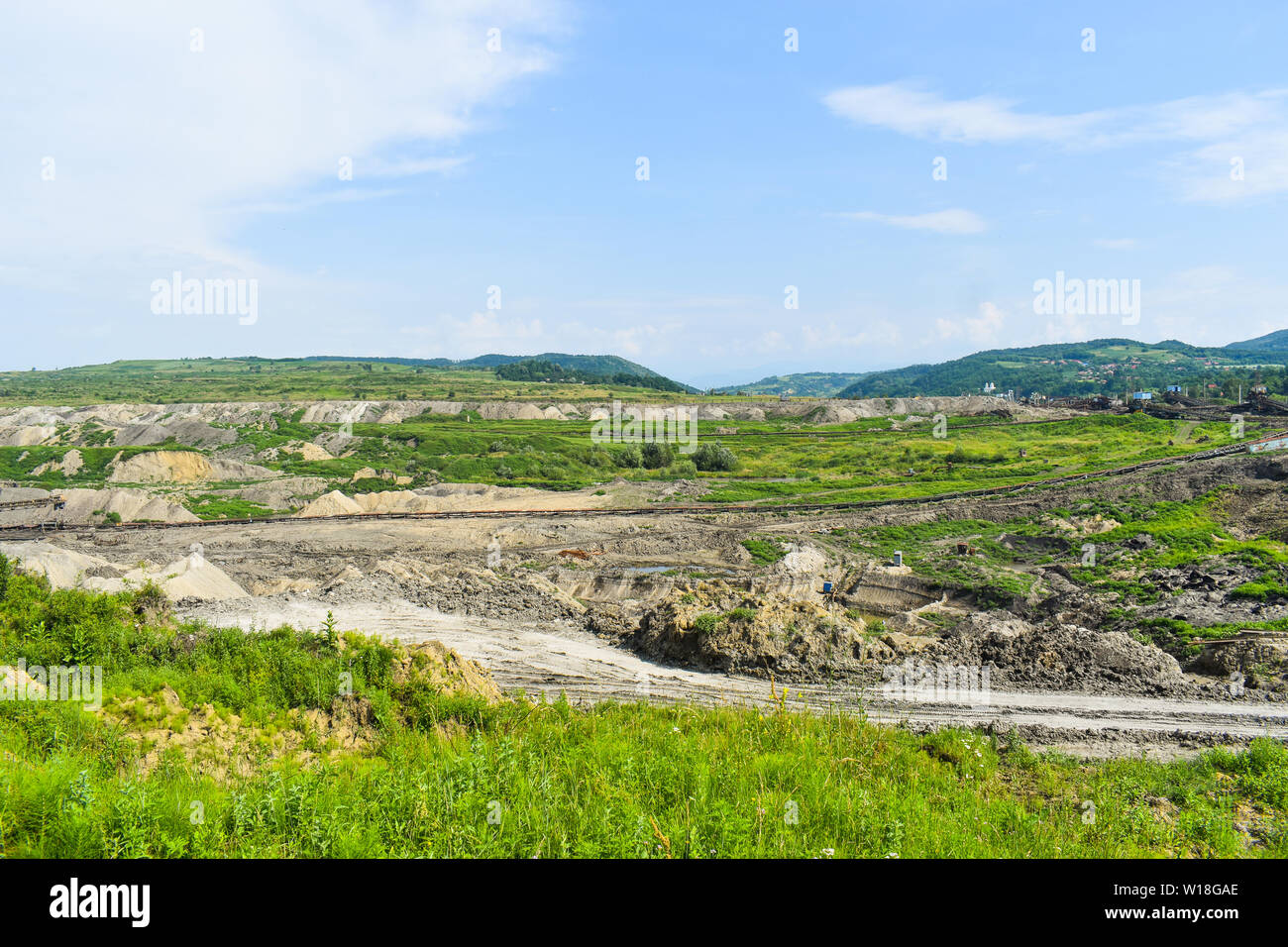 Huge open pit coal mine made with big excavators, loaders, trucks and ...