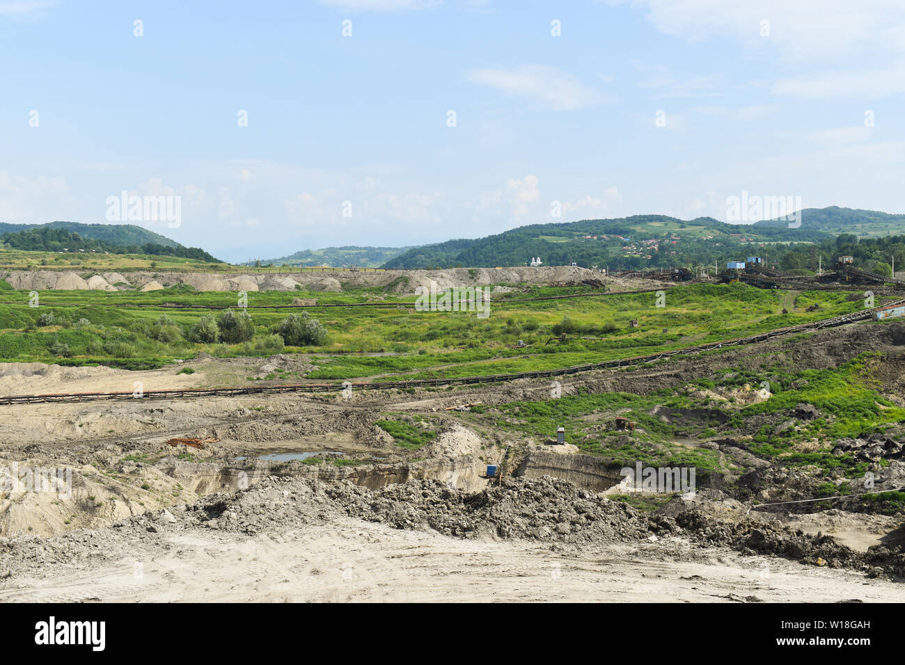 Huge open pit coal mine made with big excavators, loaders, trucks and ...