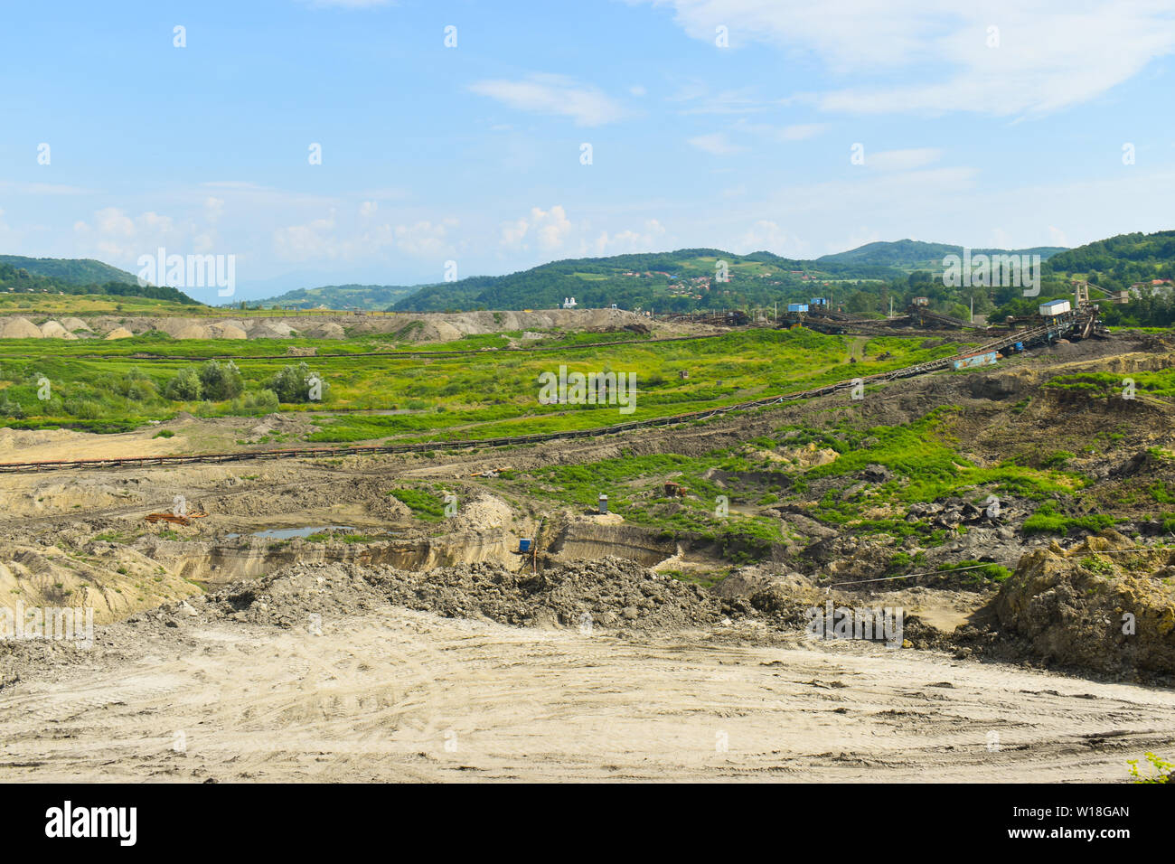 Huge open pit coal mine made with big excavators, loaders, trucks and ...