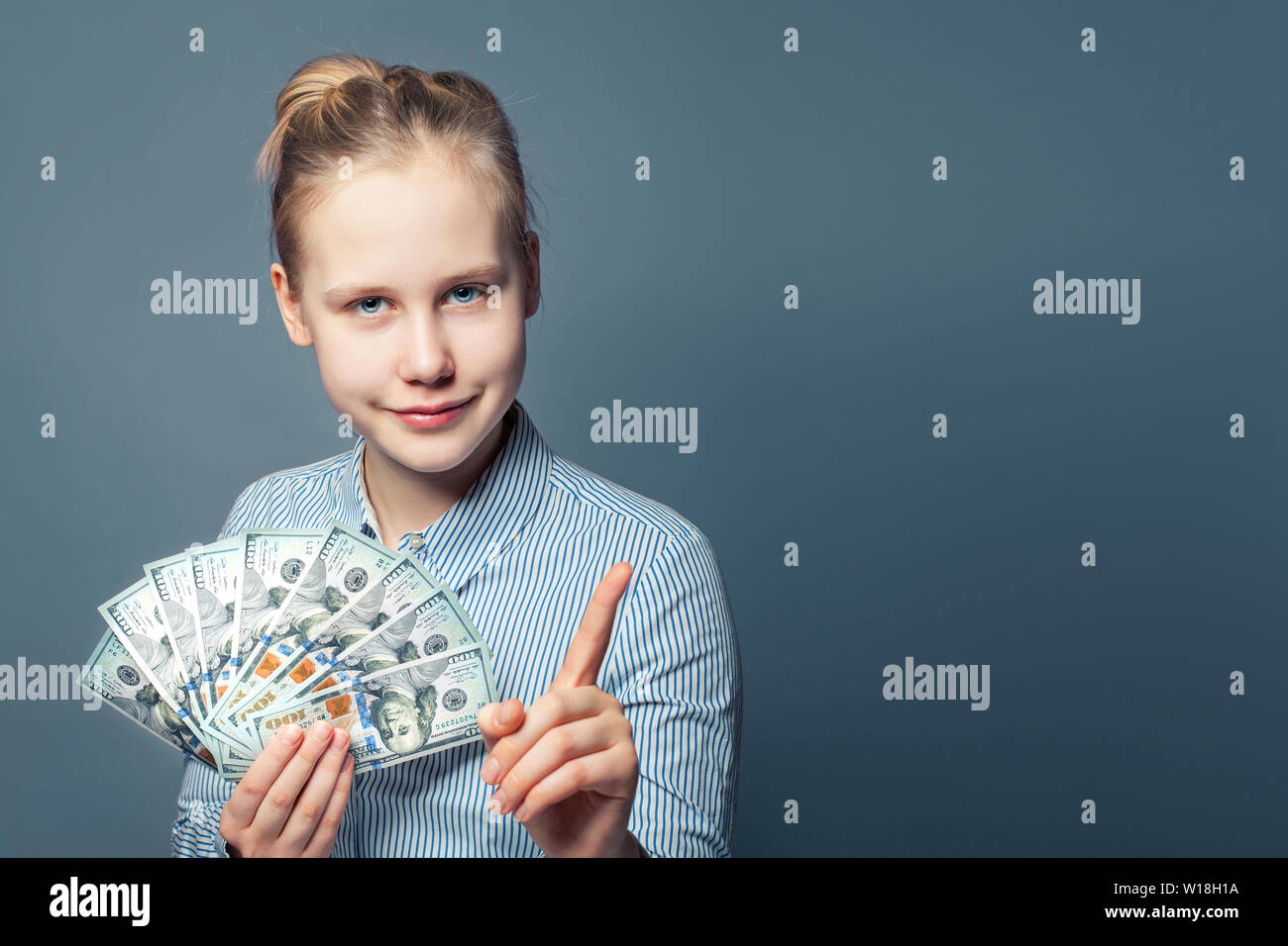 Cute smiling rich teenager girl and money cash us dollars on blue ...