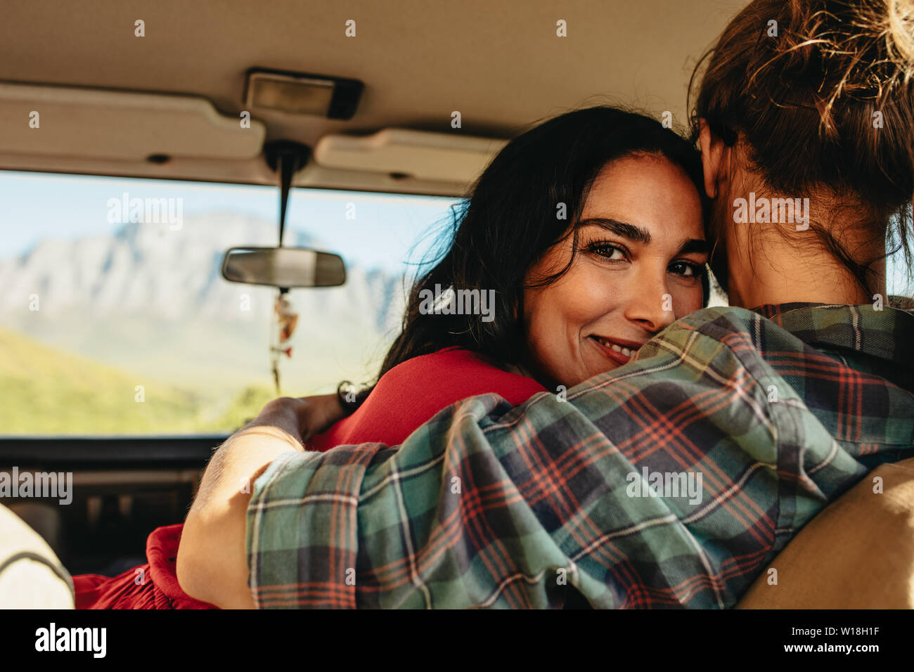 Beautiful woman embracing her boyfriend driving a car. Loving couple on ...