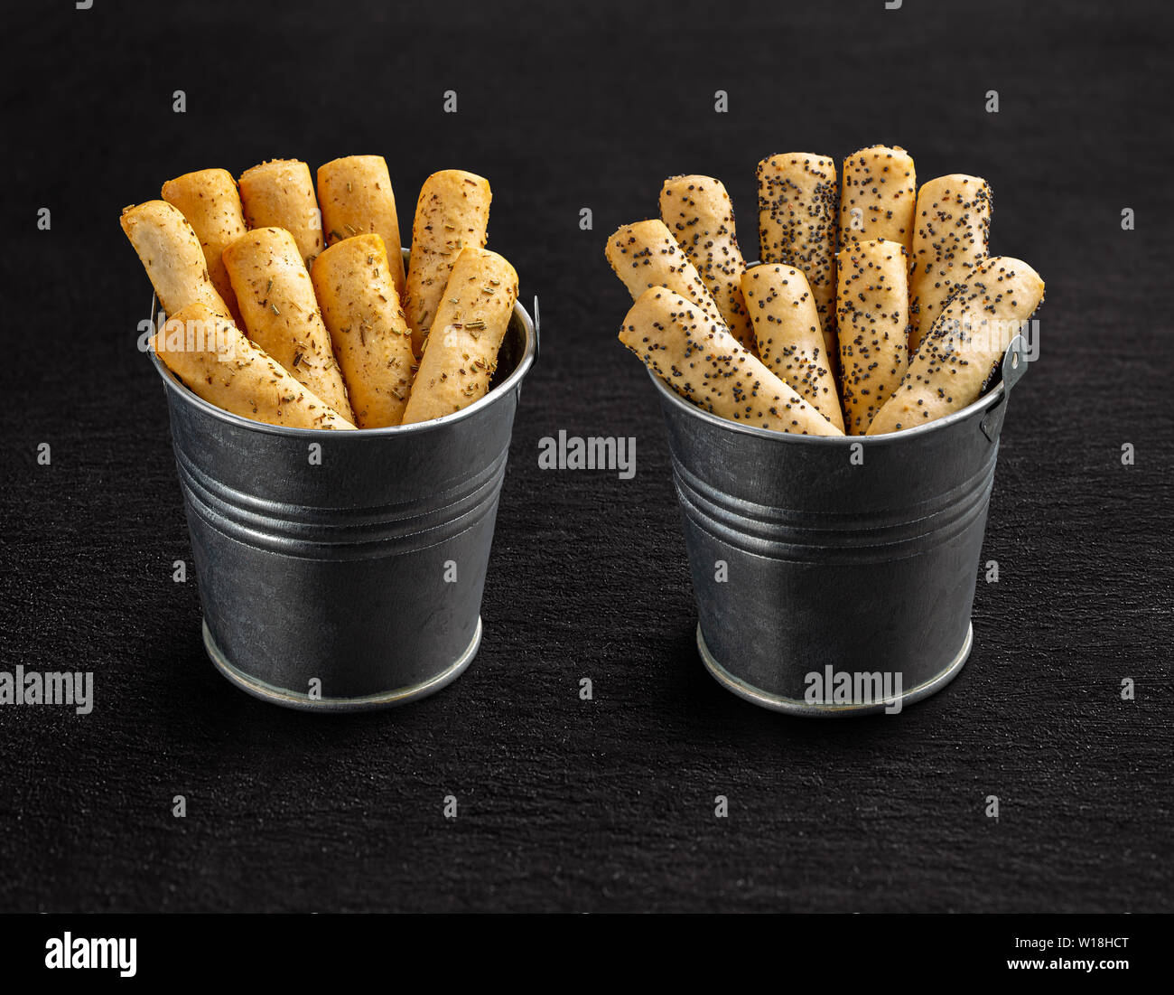 Crispy bread sticks in metal bowl on black background Stock Photo - Alamy