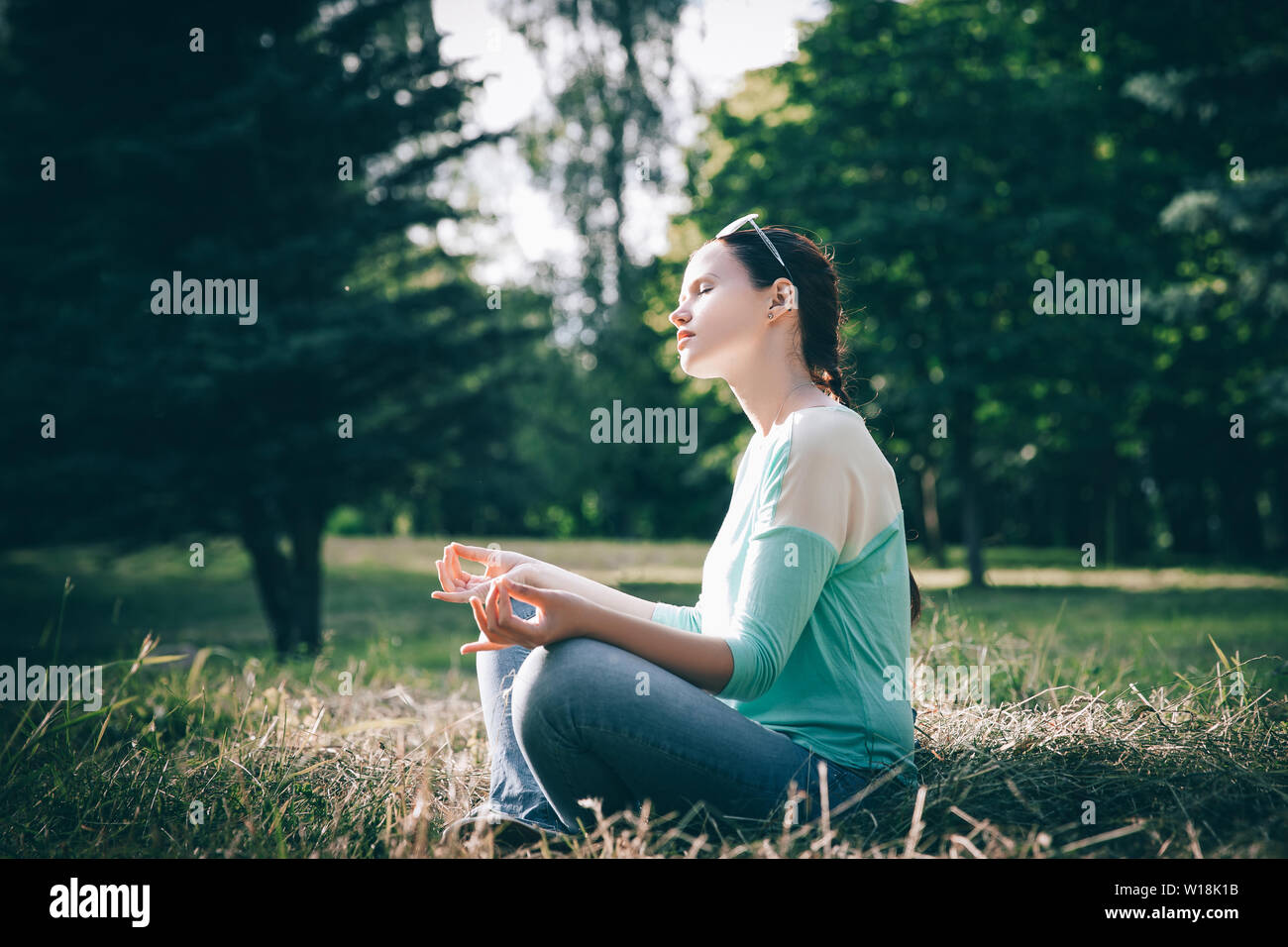 side view.beautiful woman meditating in Lotus position outdoors. the ...