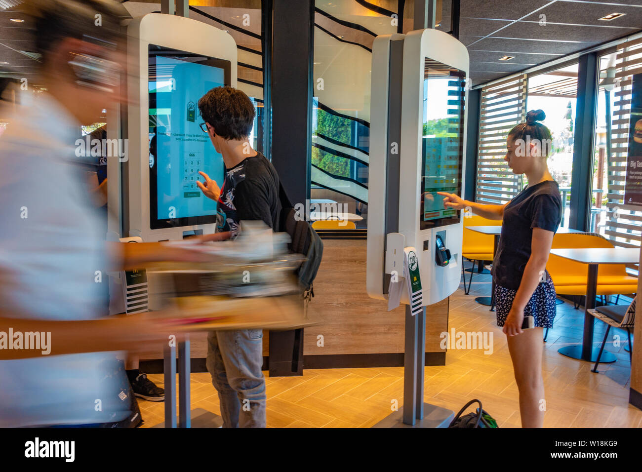Young people using the automated self-service kiosks at McDonalds Stock ...