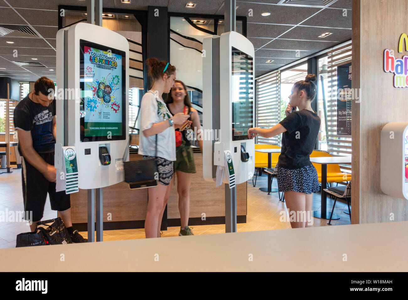 Young people using the automated self-service kiosks at McDonalds Stock ...