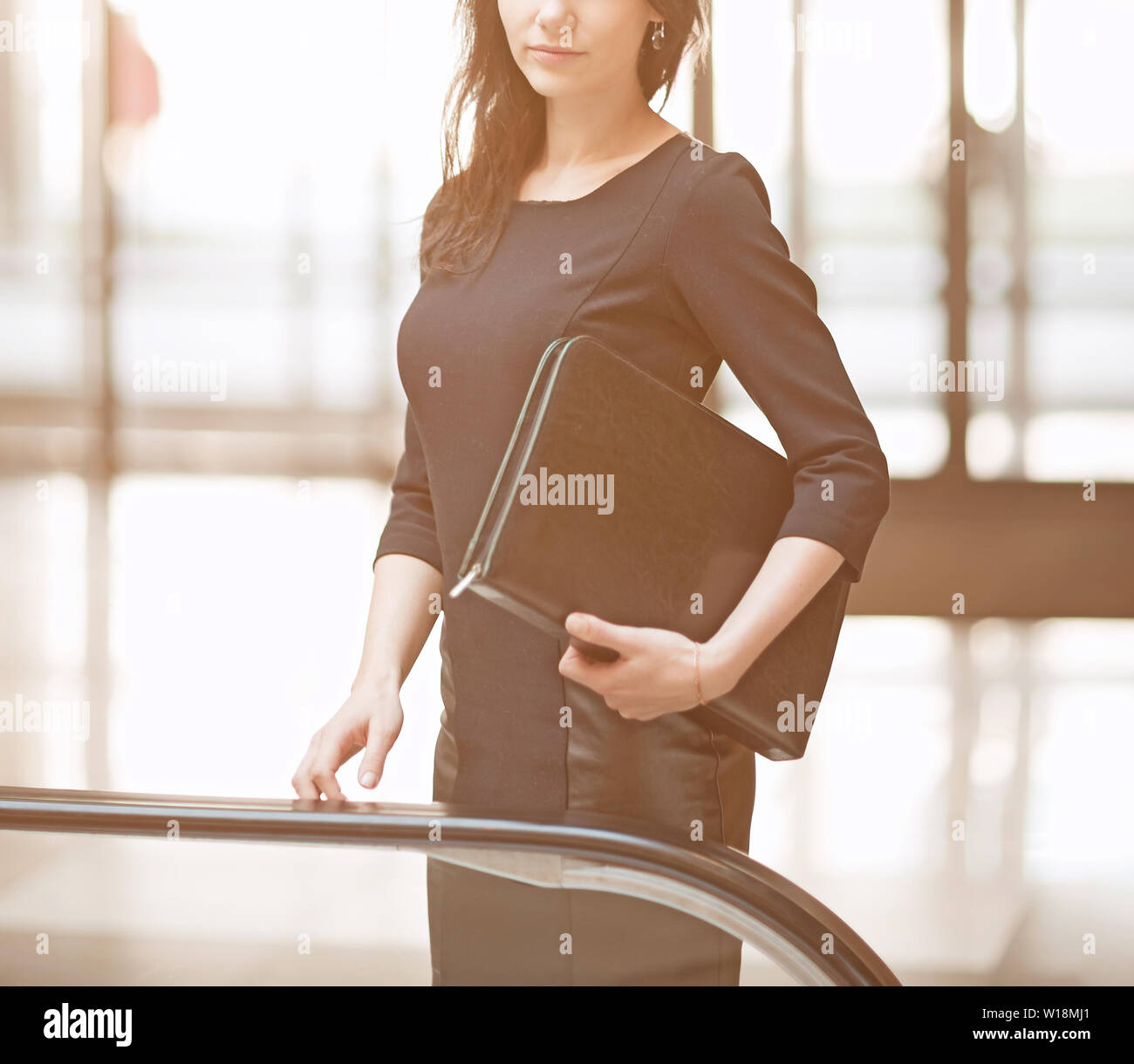 Executive businesswoman with clipboard standing in the office lobby ...