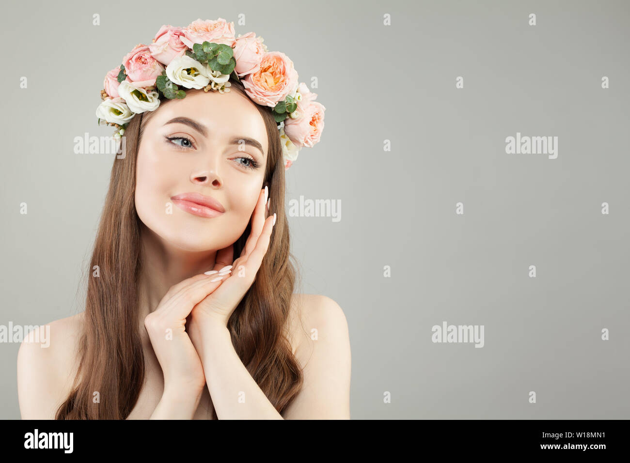 Portrait of pretty spa woman with healthy skin, long hair and flowers ...