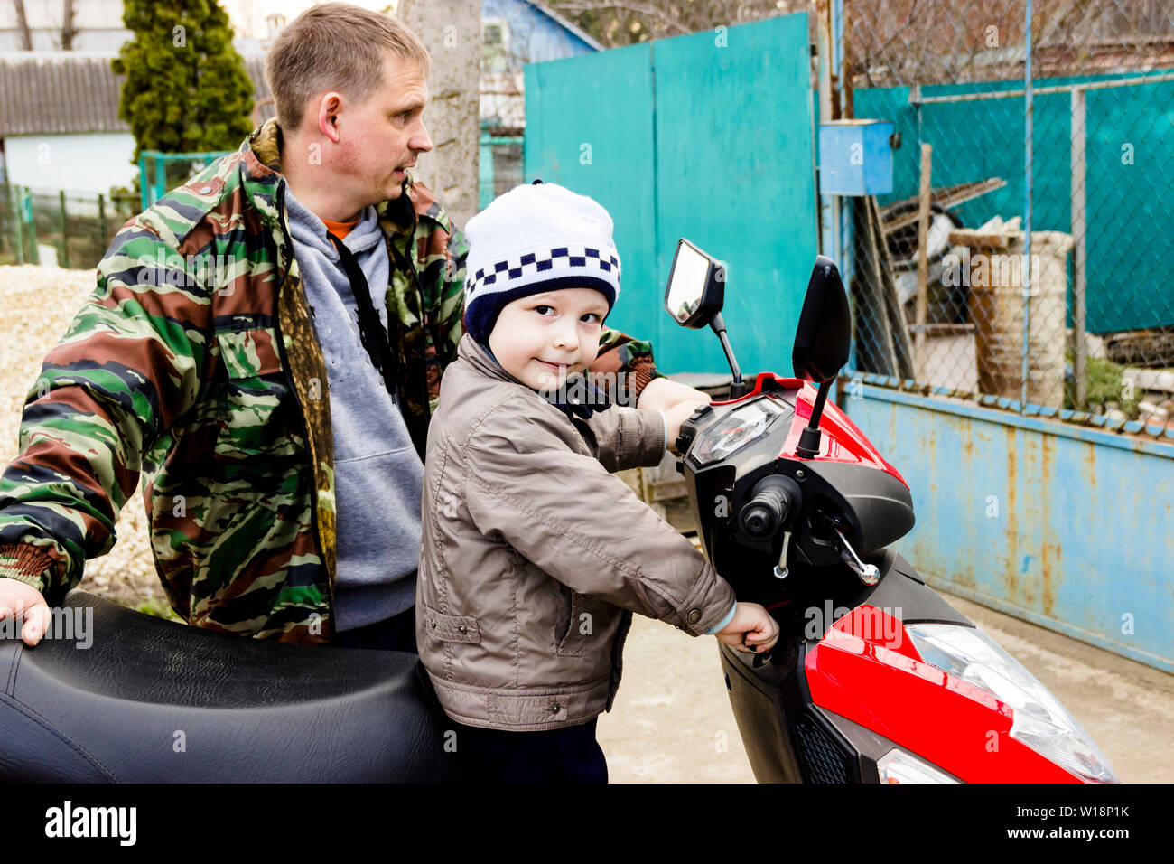 pictured in the photo a little boy is sitting on a red motorcycle Stock ...