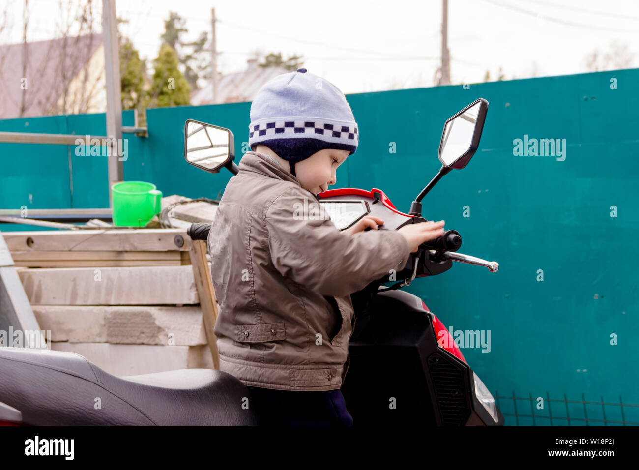 pictured in the photo a little boy is sitting on a red motorcycle Stock ...