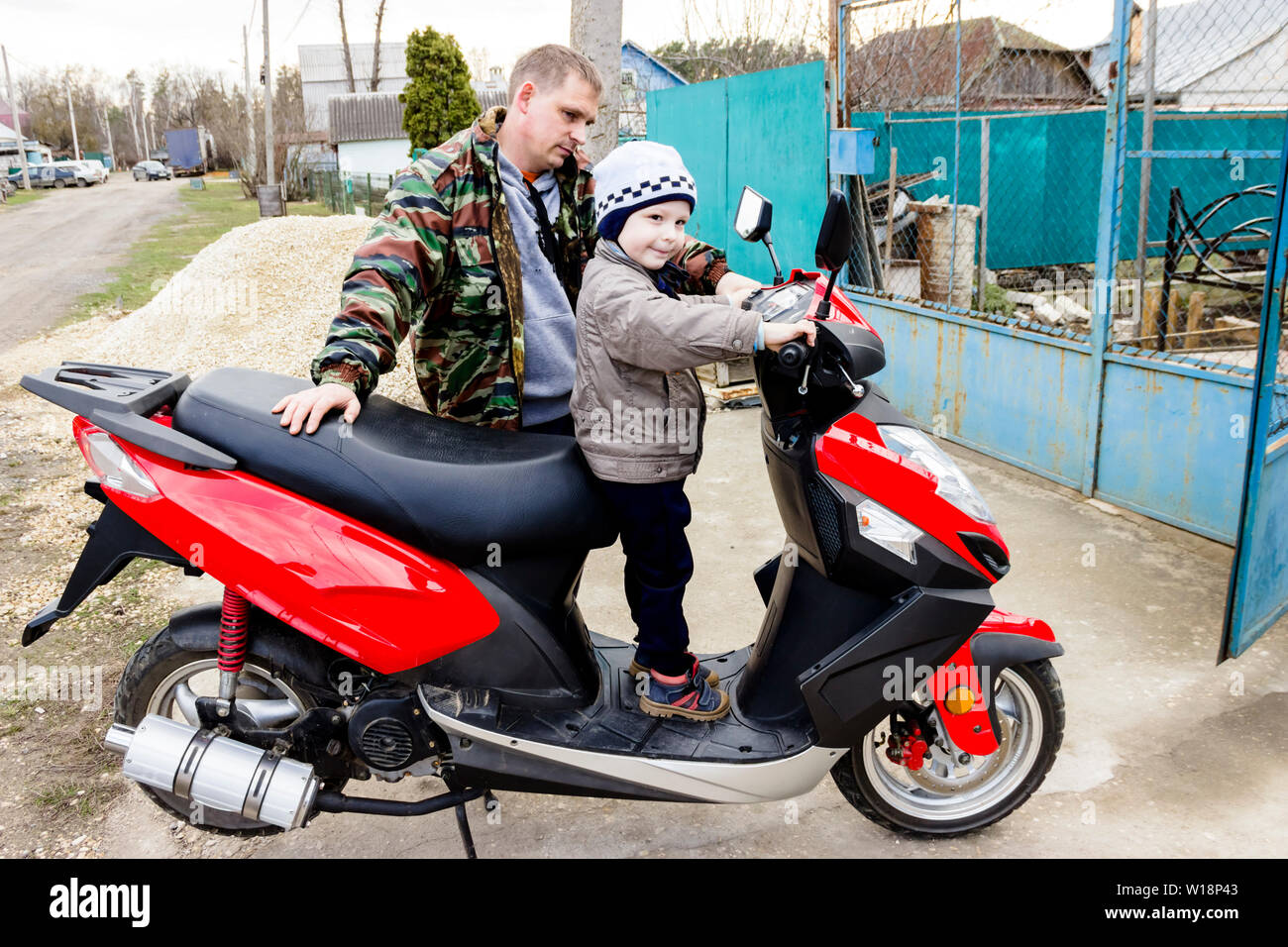 pictured in the photo a little boy is sitting on a red motorcycle Stock ...