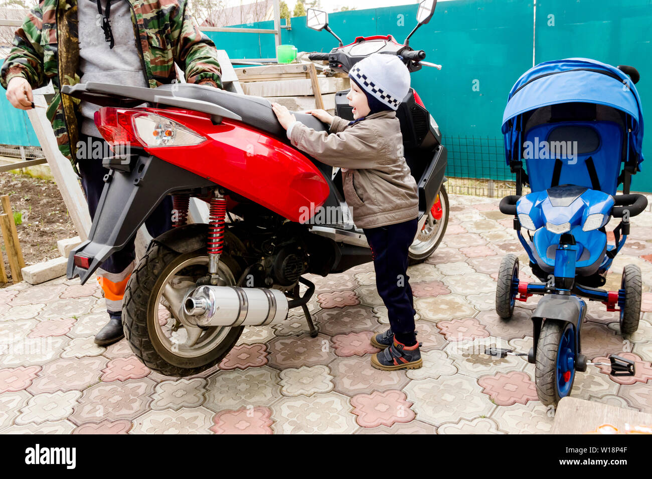 pictured in the photo a little boy is sitting on a red motorcycle Stock ...