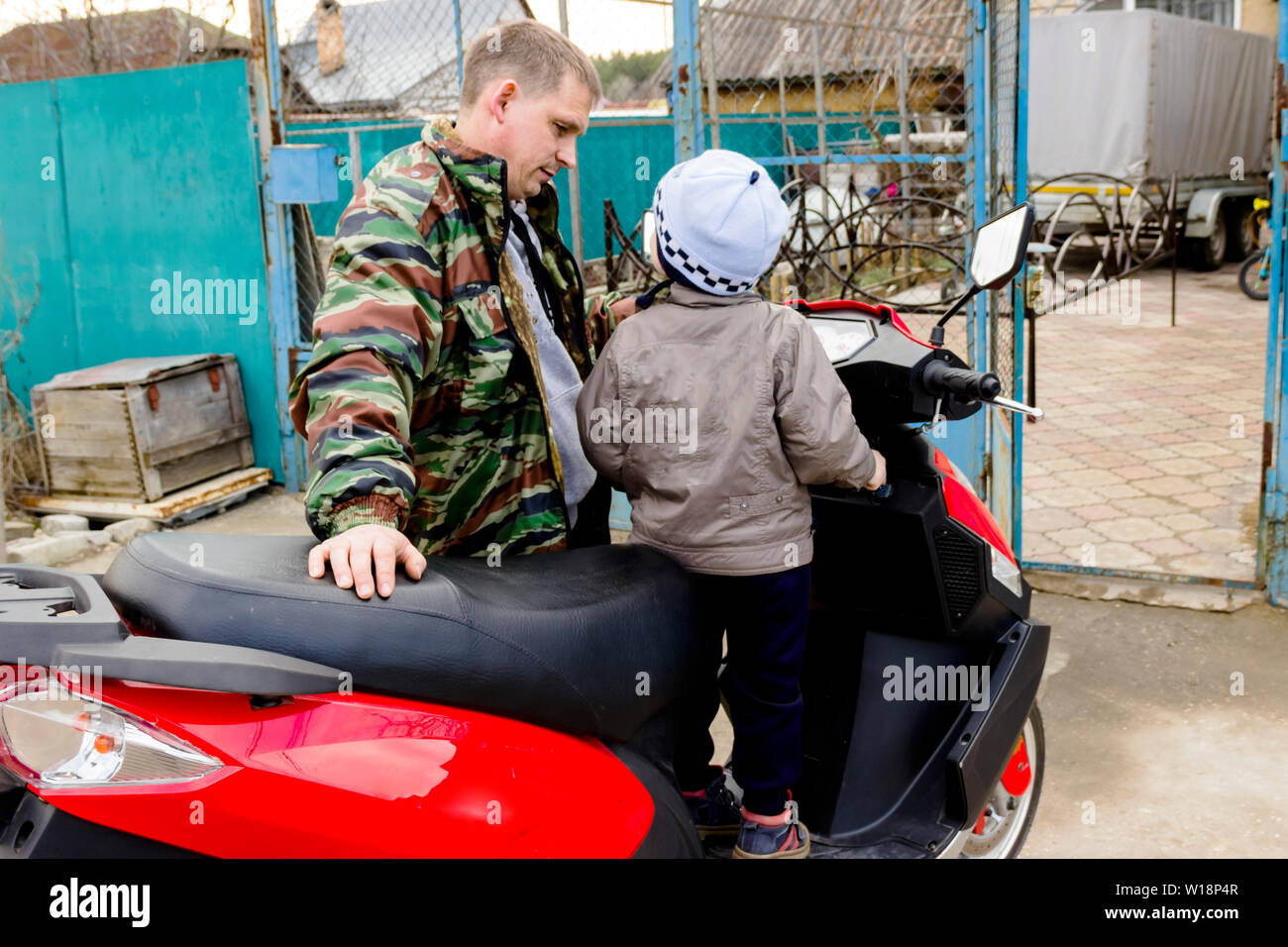 pictured in the photo a little boy is sitting on a red motorcycle Stock ...
