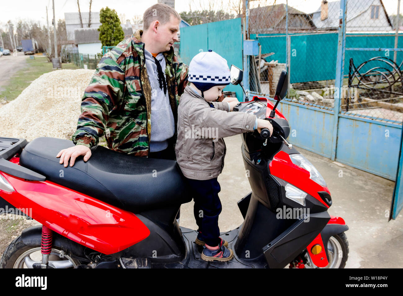 pictured in the photo a little boy is sitting on a red motorcycle Stock ...