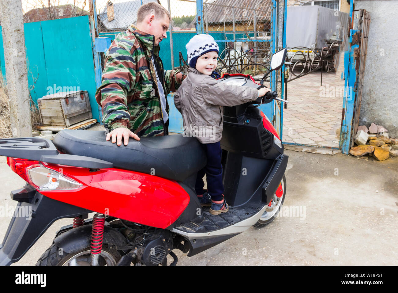 pictured in the photo a little boy is sitting on a red motorcycle Stock ...