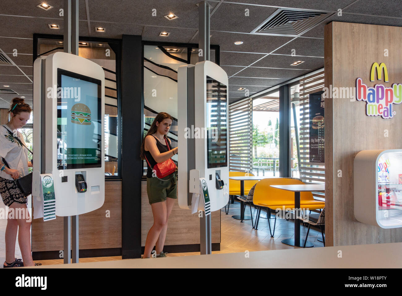 Young girl using the automated self-service kiosks at McDonalds Stock ...