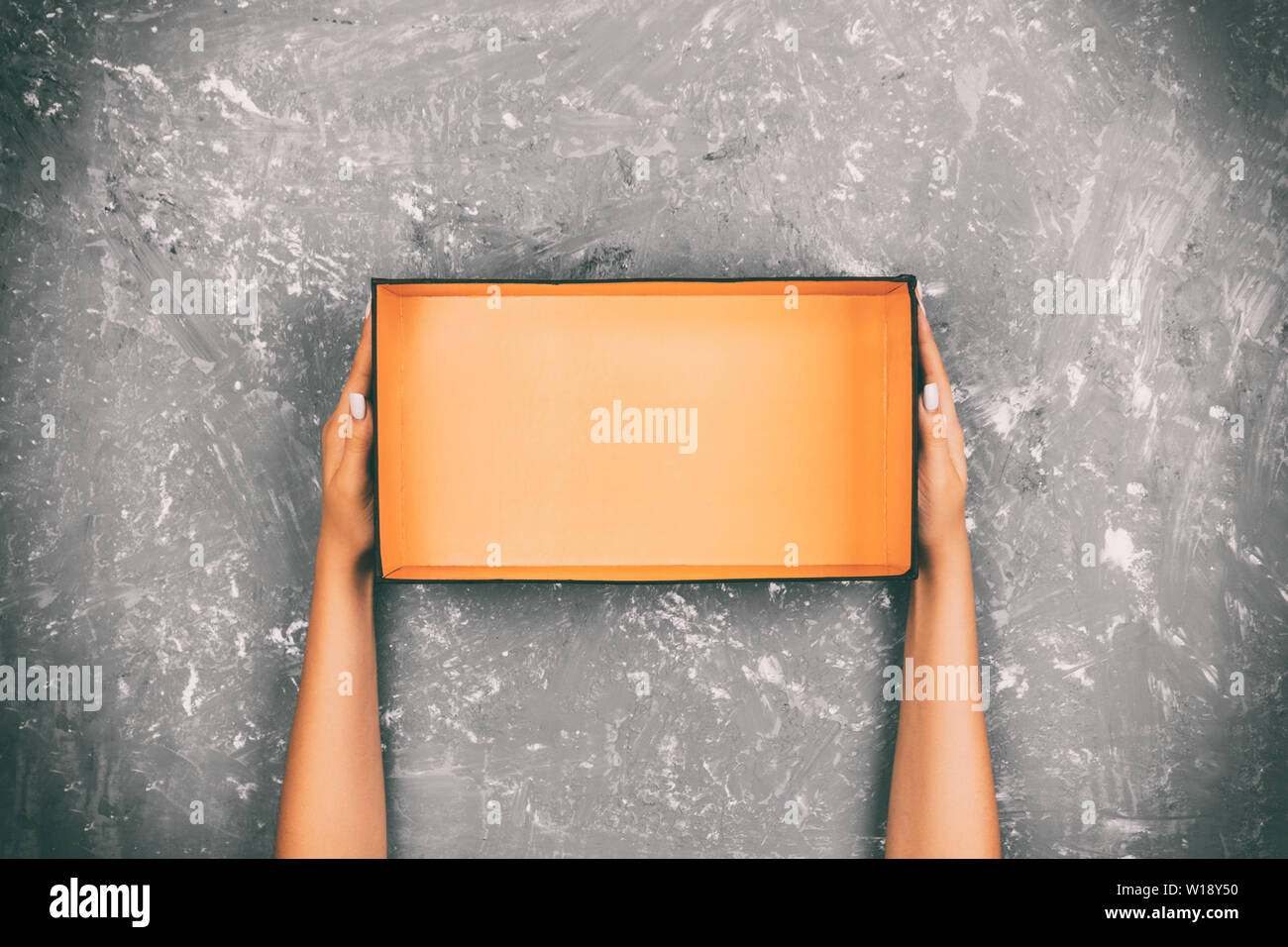 Girl hands holding open empty box on gray background Stock Photo - Alamy