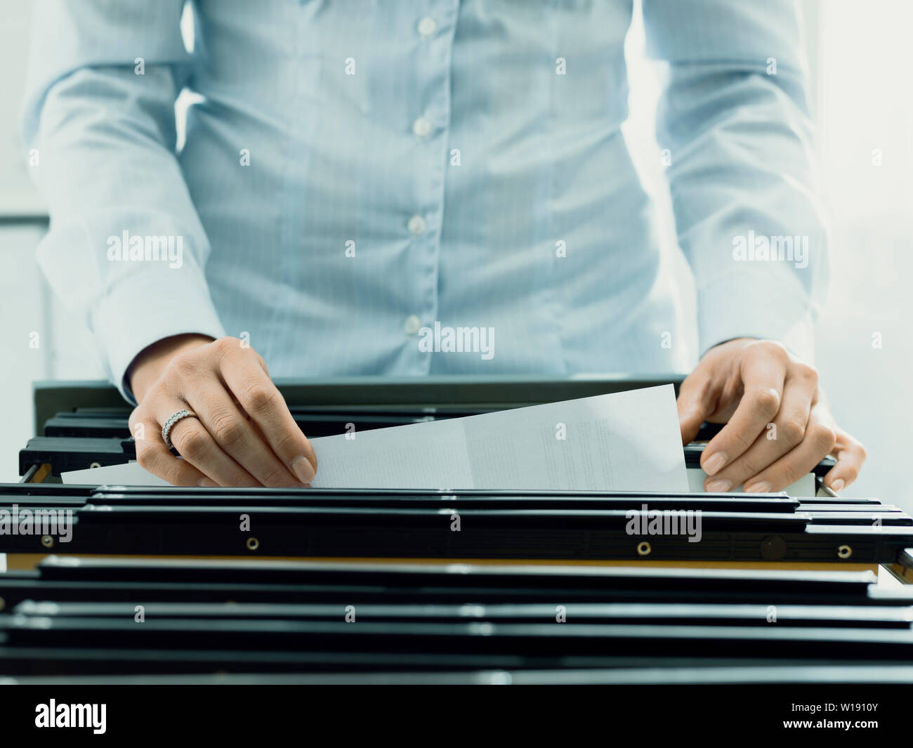 A woman filing documents into a cabinet hi-res stock photography and ...