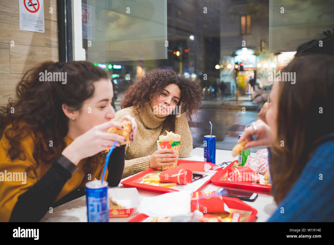 group of young girlfriends having dinner in fast food – hungry, union ...