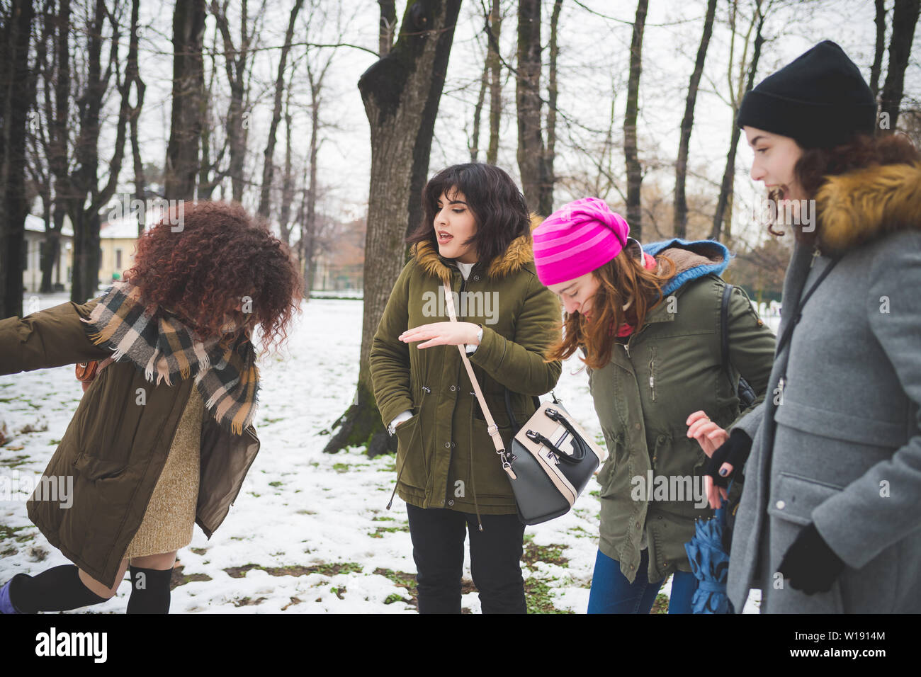 group of young women talking in park with snow cover – communication ...