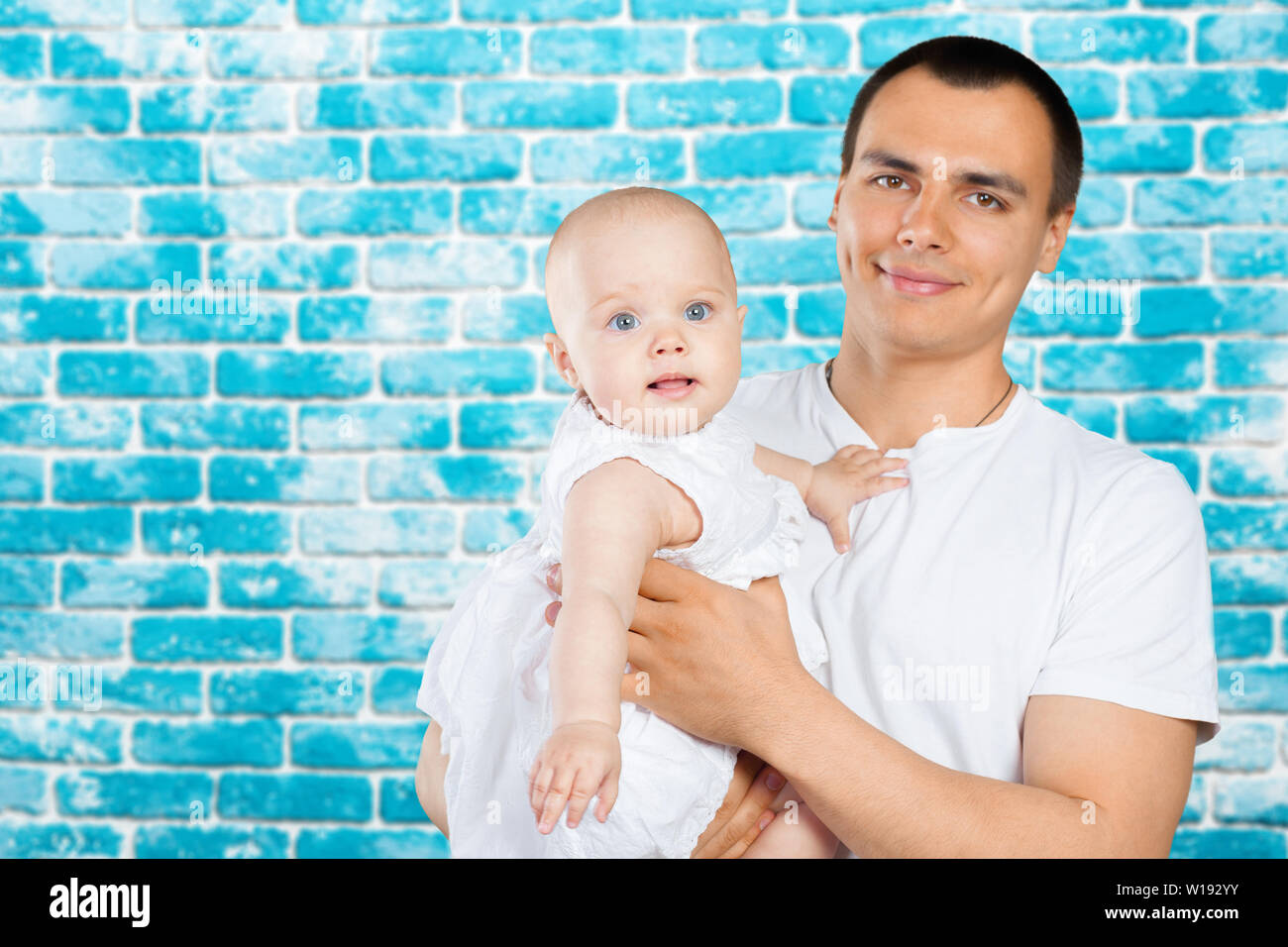 Happy young man holding a baby Stock Photo - Alamy