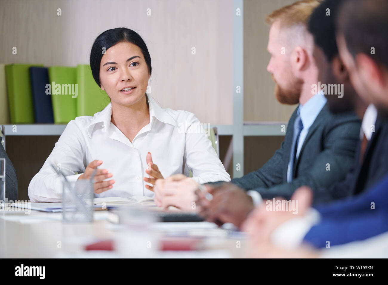 Young confident mixed-race businesswoman answering questions of her ...