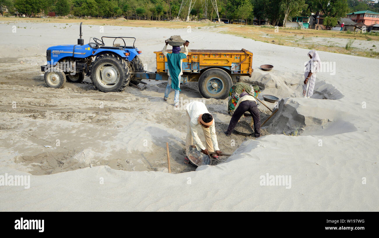 Manual worker loading sand on Tractor at River bank Stock Photo - Alamy