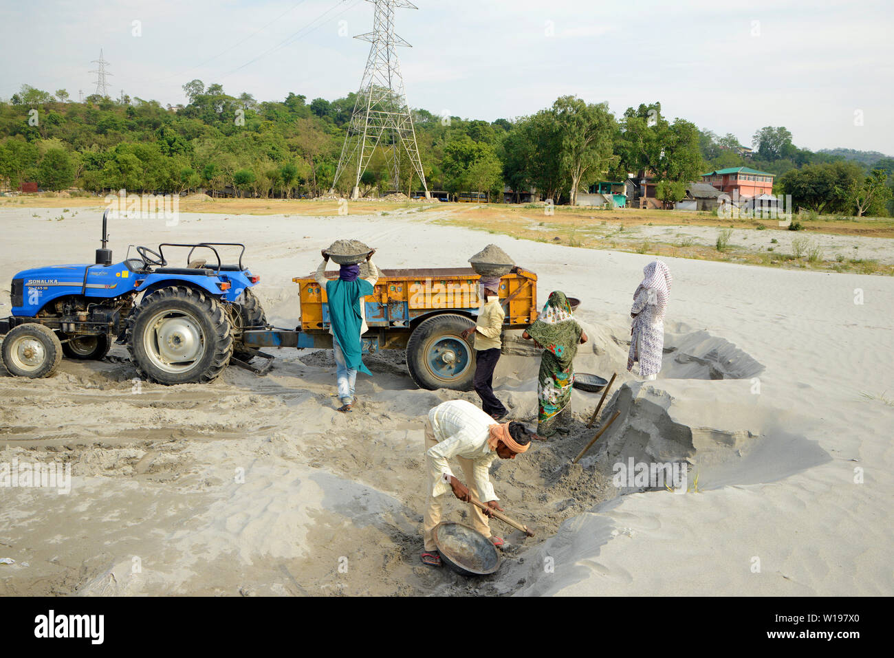 Manual worker loading sand on Tractor at River bank Stock Photo - Alamy