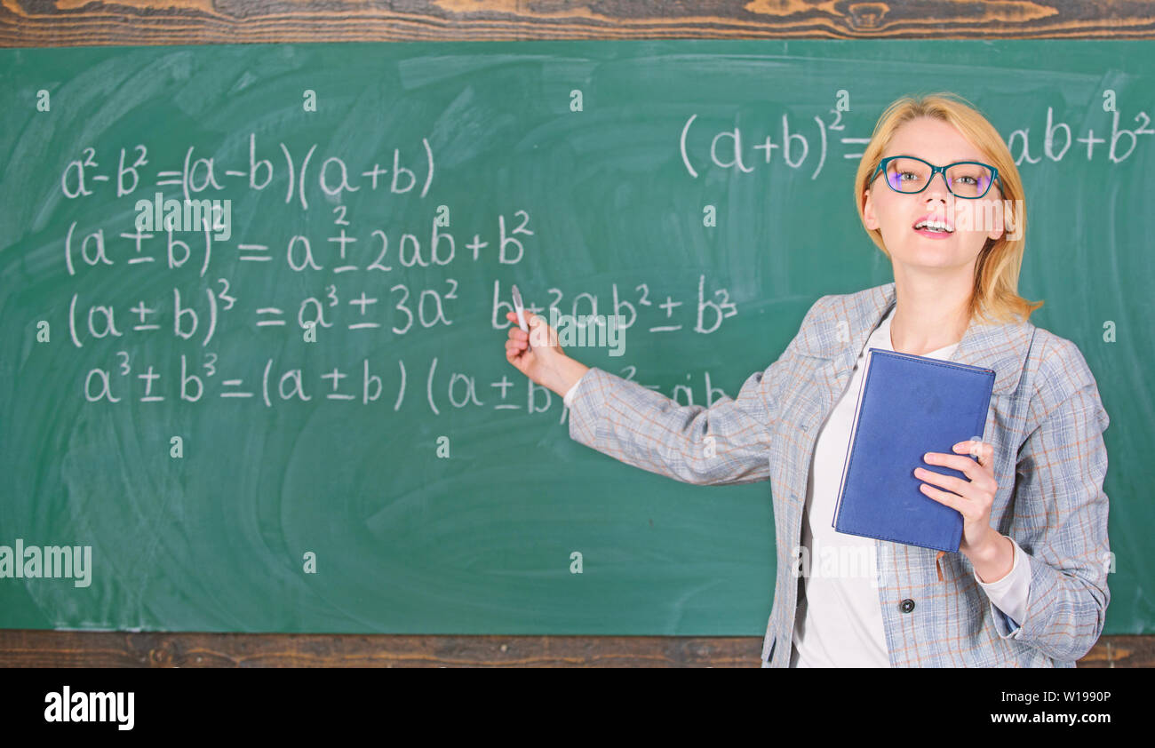 Teacher smart woman with book explain topic near chalkboard. School ...