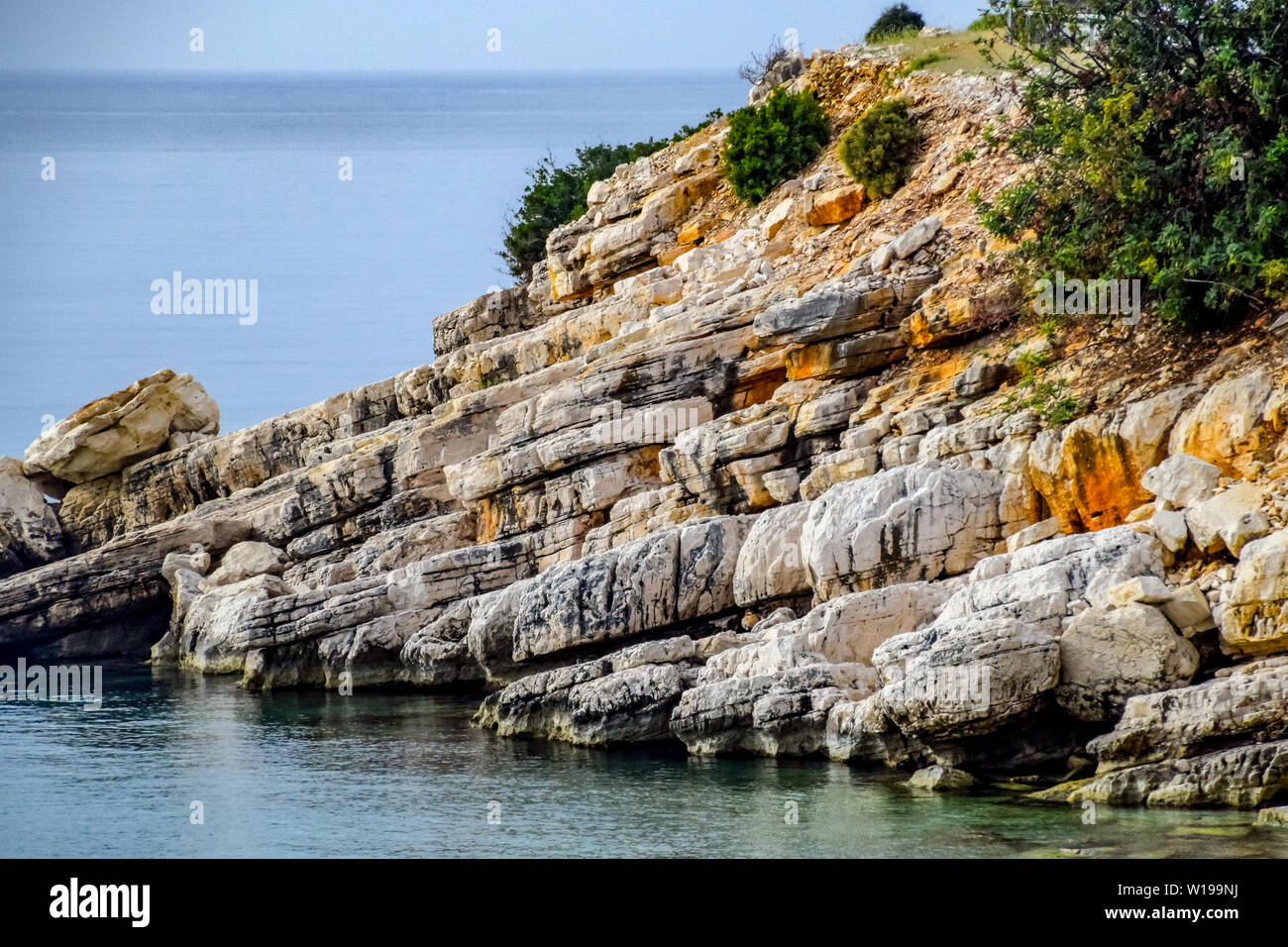 Sedimentary rocks of limestone and white marble on the shores of the ...