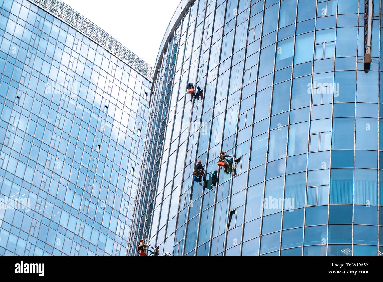 Two workers clean the exterior of a building hi-res stock photography ...