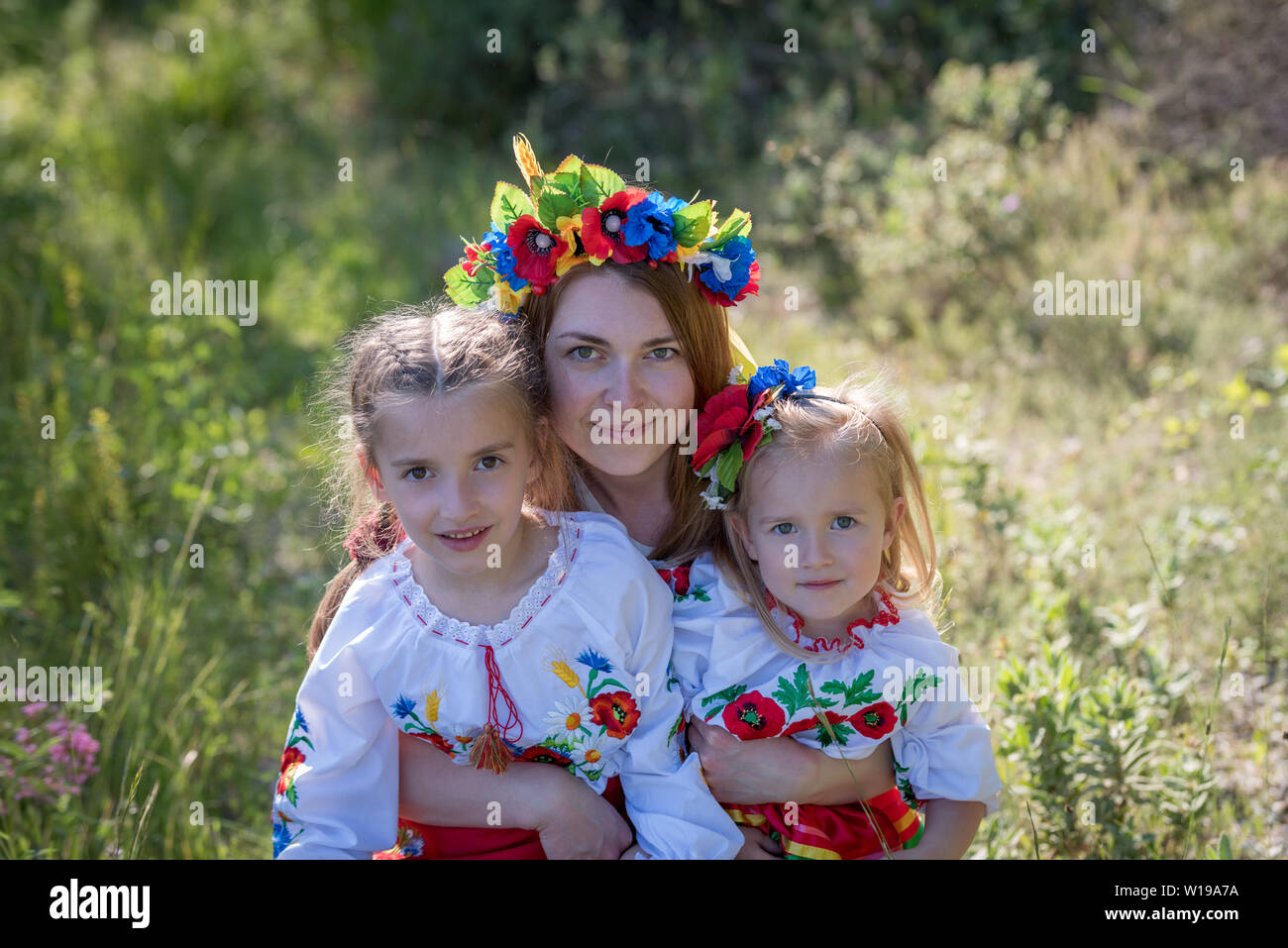 Mother and daughters in traditional Ukrainian costumes posing in the ...