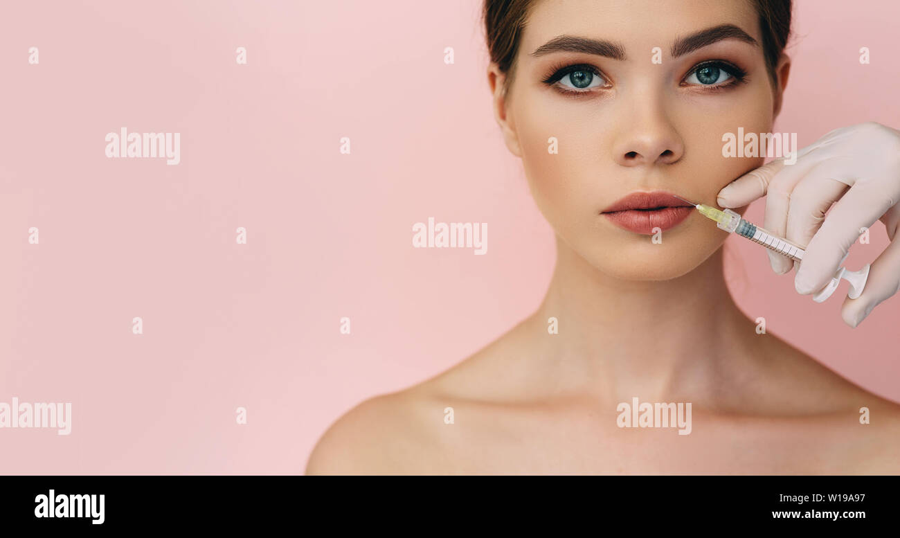 woman's plumper lips, getting bigger lips. prick of a syringe for the ...