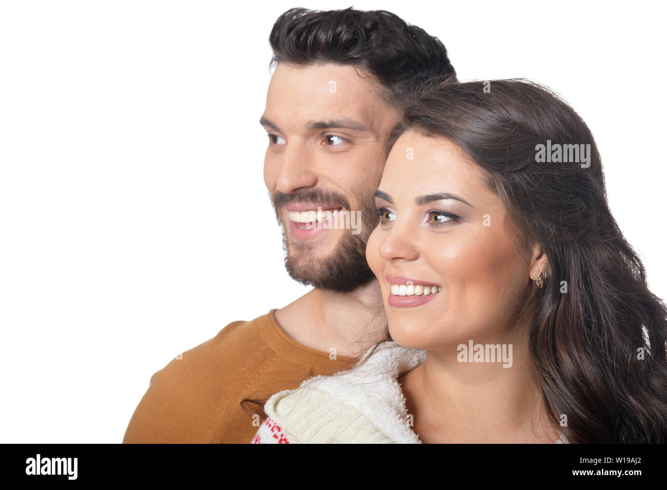 Portrait of happy young couple smiling and hugging on white background ...